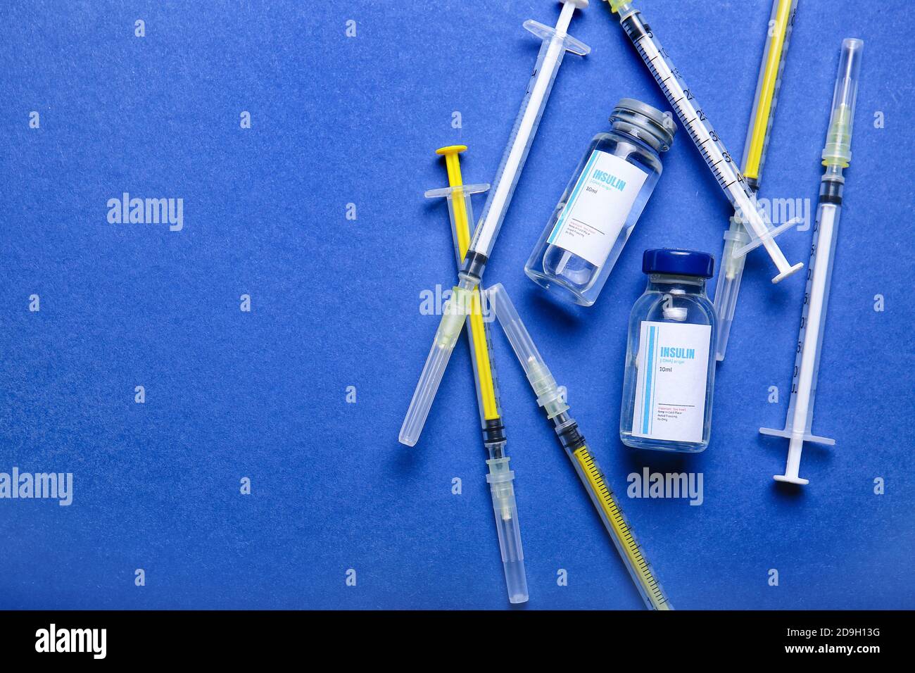 Bottles of insulin with syringes on color background. Diabetes concept ...