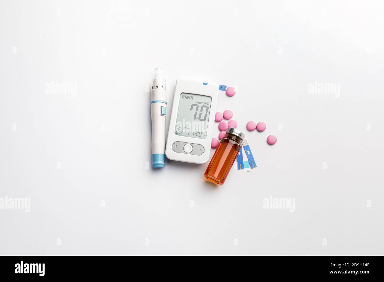 Glucometer, lancet pen, pills and bottle of insulin on white background ...