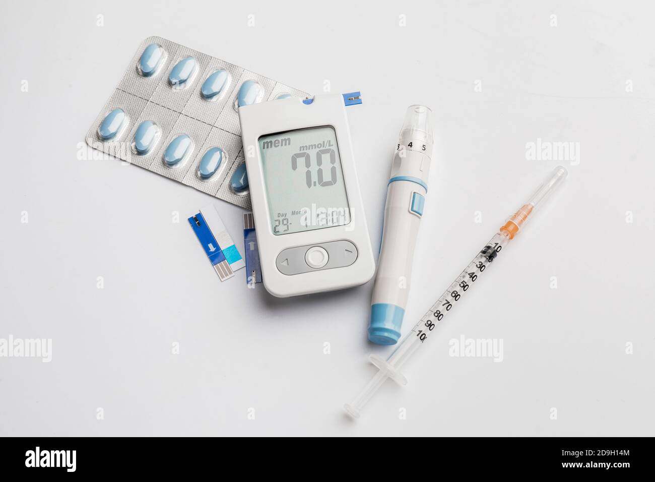Glucometer, lancet pen, pills and syringe on white background. Diabetes ...