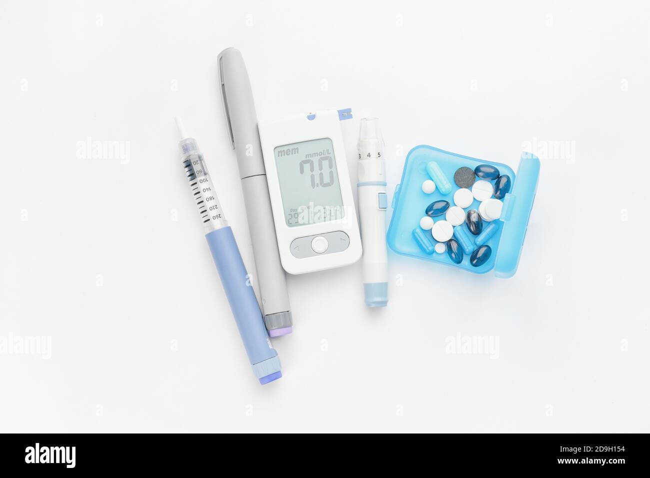 Glucometer, lancet pens, pills and syringe on white background ...