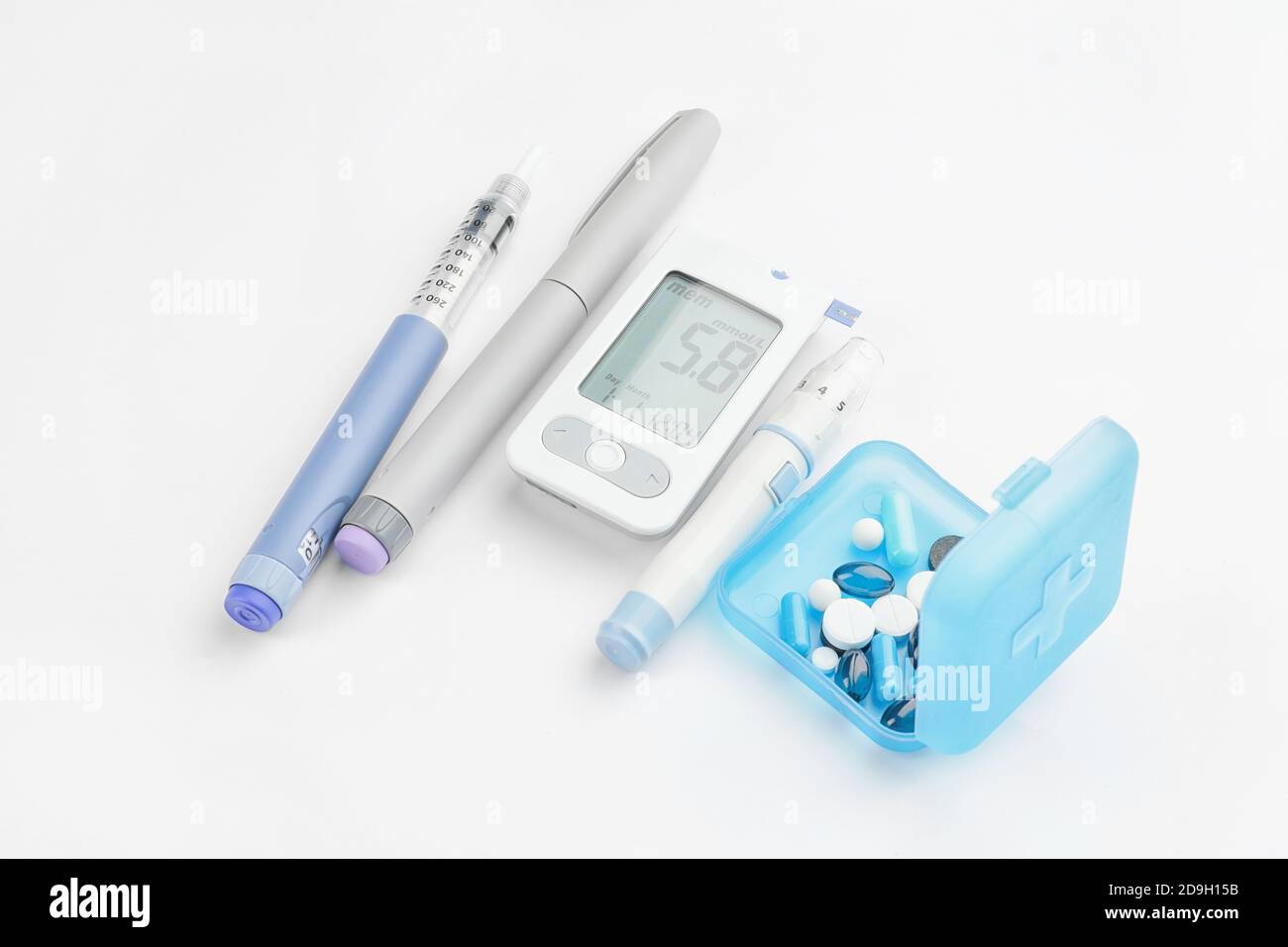 Glucometer, lancet pens, pills and syringe on white background ...