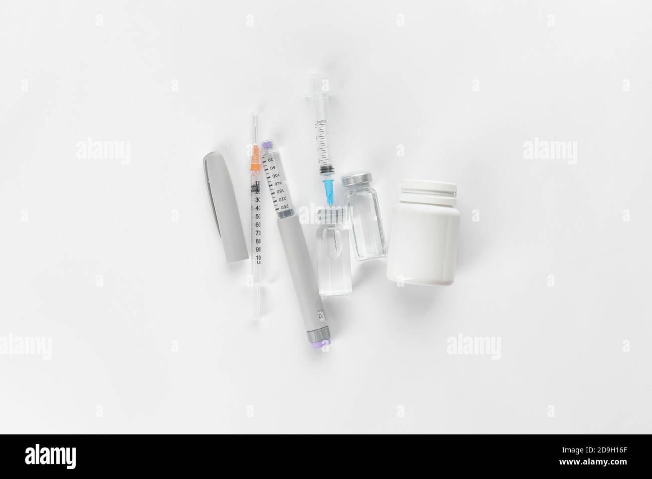 Syringes, bottles of insulin and pills on white background. Diabetes ...