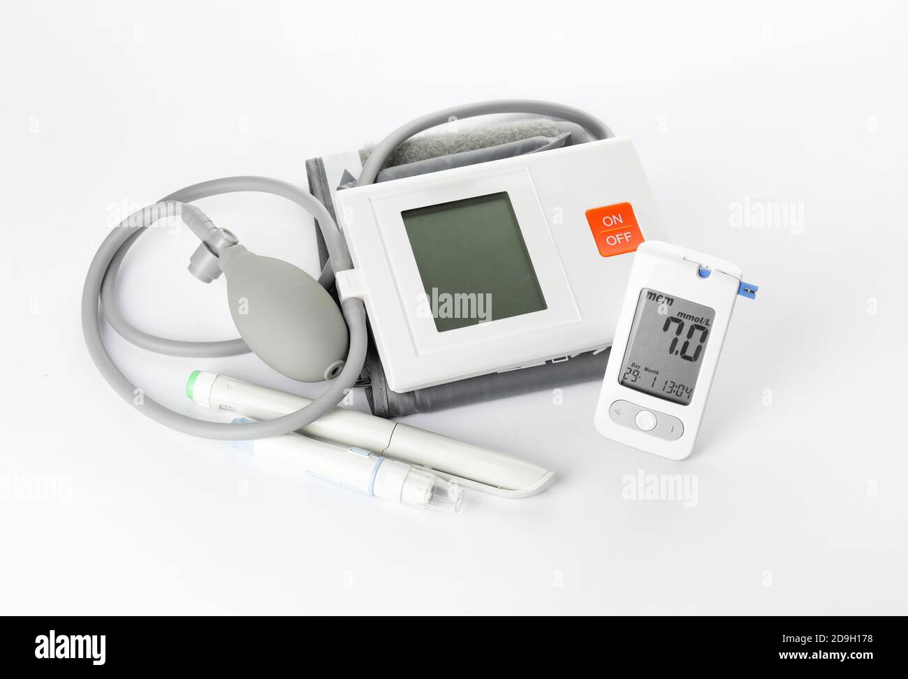 Glucometer with sphygmomanometer, syringe and lancet pen on white ...