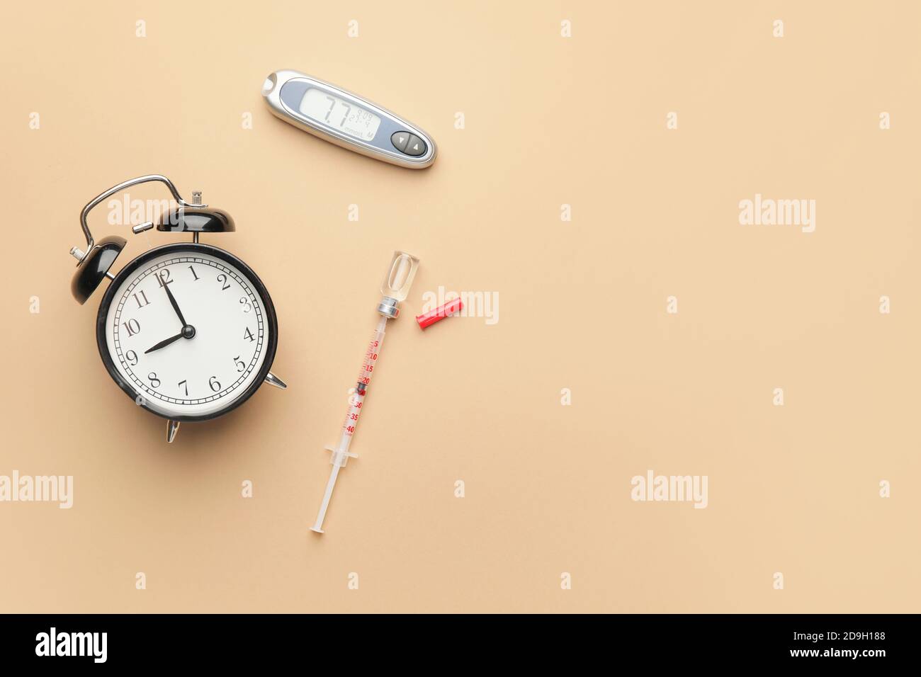 Glucometer with alarm clock, syringe and bottle of insulin on color ...