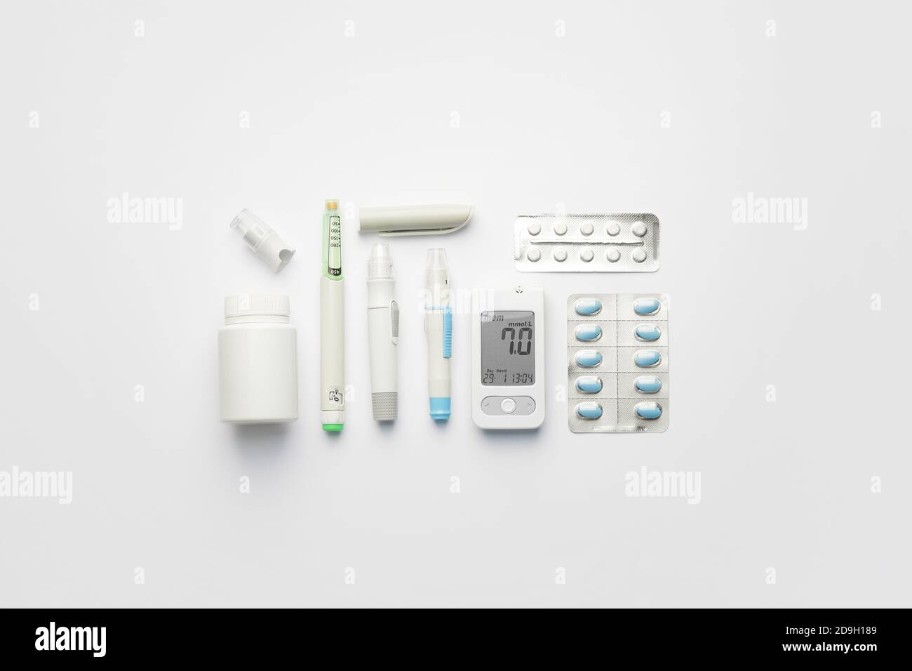 Glucometer, pills, lancet pens and syringe on white background ...