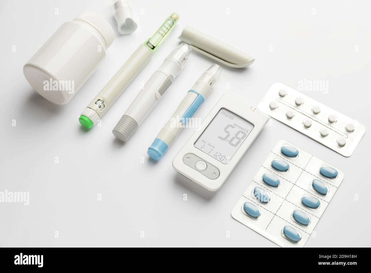Glucometer, pills, lancet pens and syringe on white background ...