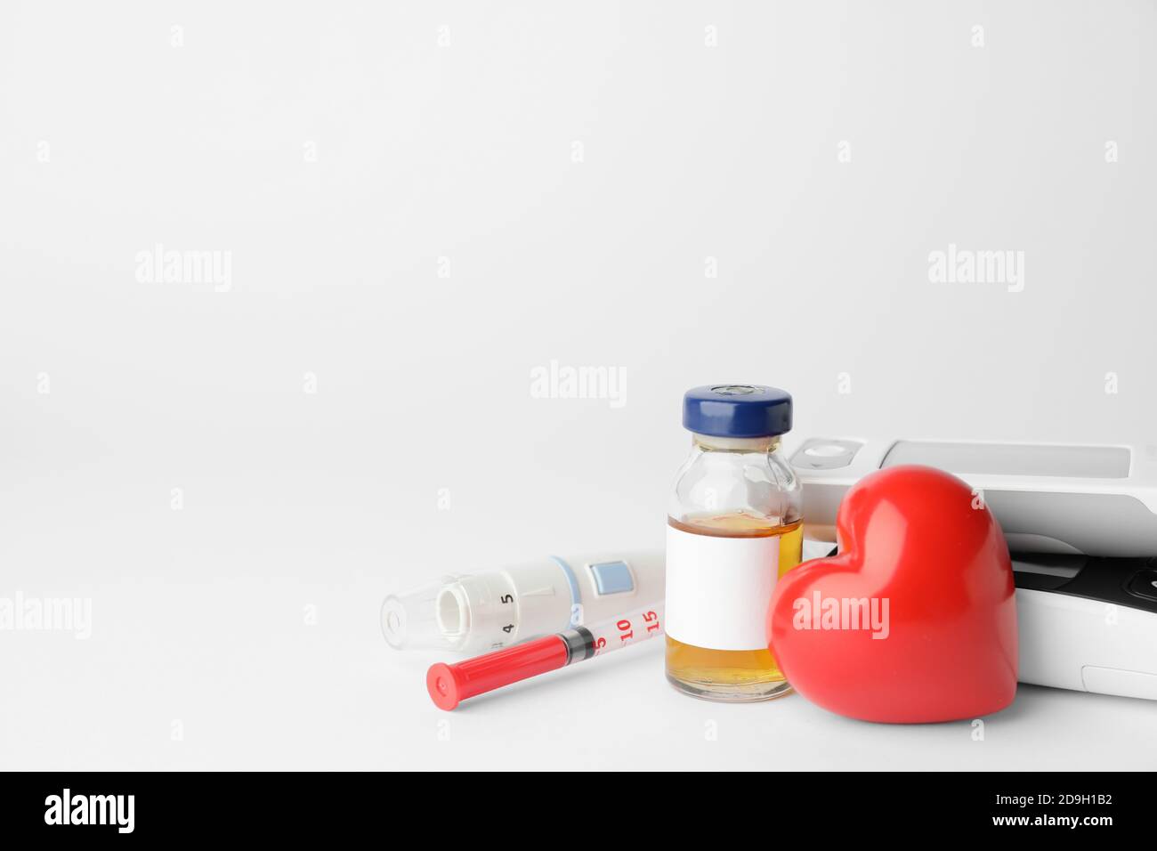 Glucometers with heart, bottle of insulin, lancet pen and syringe on ...