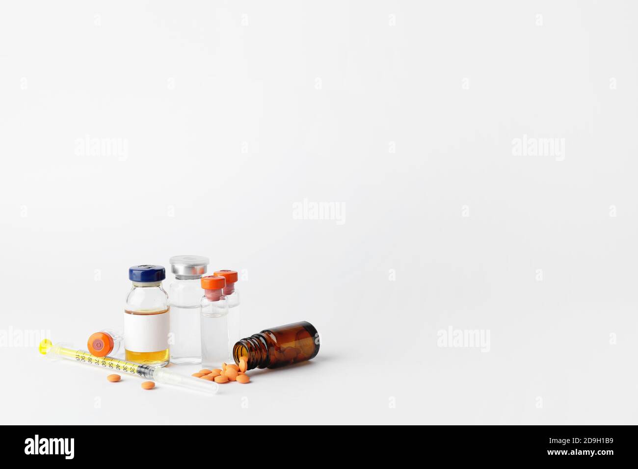 Bottles of insulin with pills and syringe on white background. Diabetes ...
