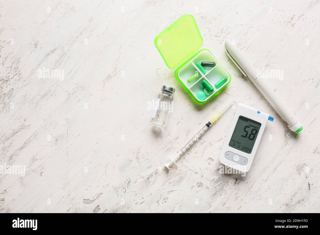 Glucometer with lancet pen, medications and syringe on white background ...
