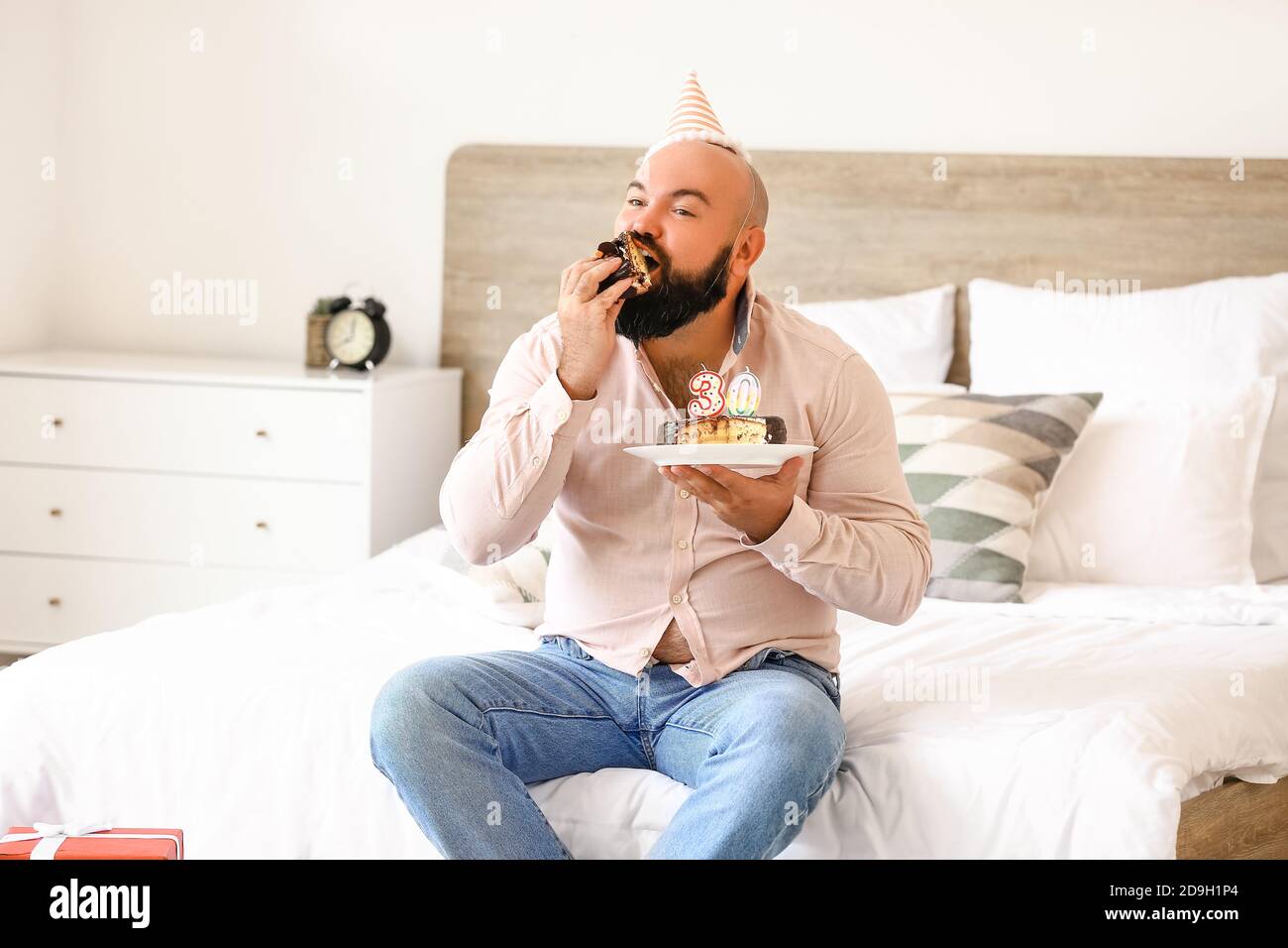 Overweight man celebrating birthday at home Stock Photo - Alamy