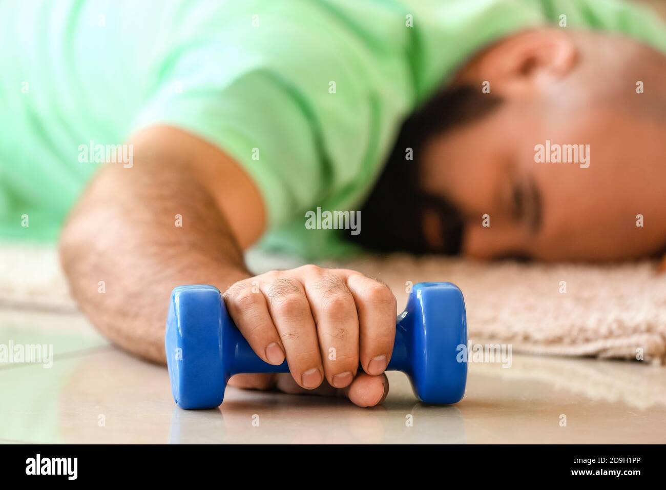Exhausted overweight man lying on floor after training at home. Weight ...
