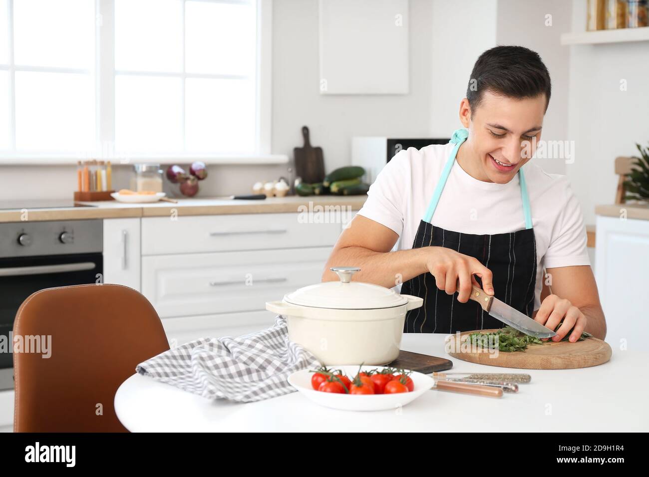 Young man cooking food in kitchen Stock Photo - Alamy