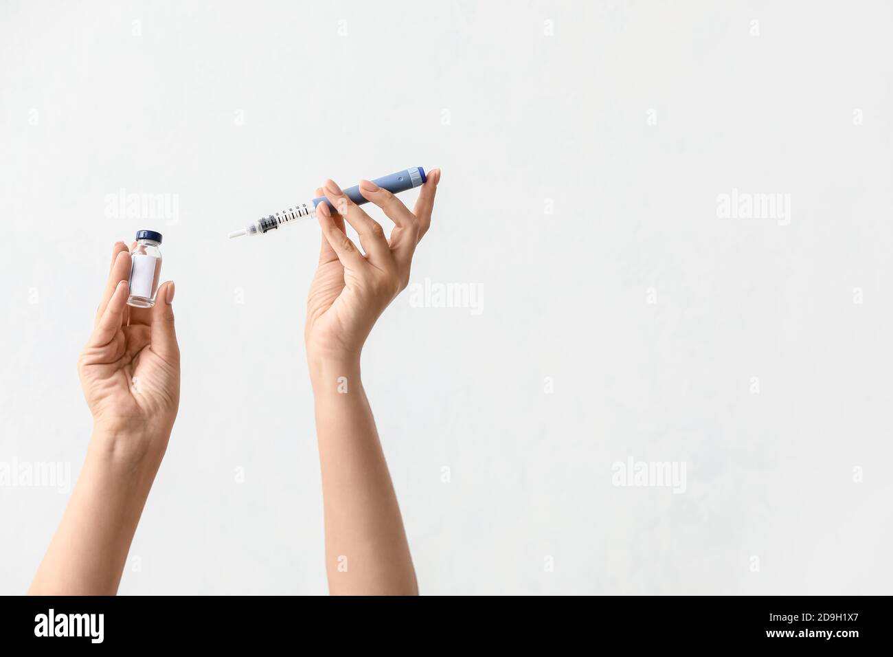 Female hands with bottle of insulin and syringe on light background ...