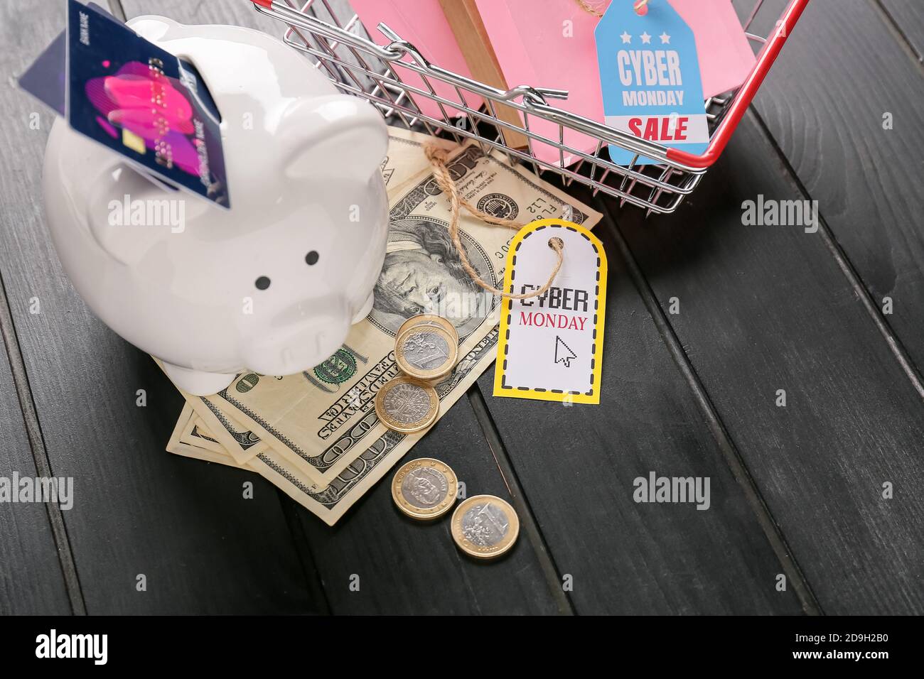 Piggy bank with money, shopping basket, bags and tags with text CYBER ...