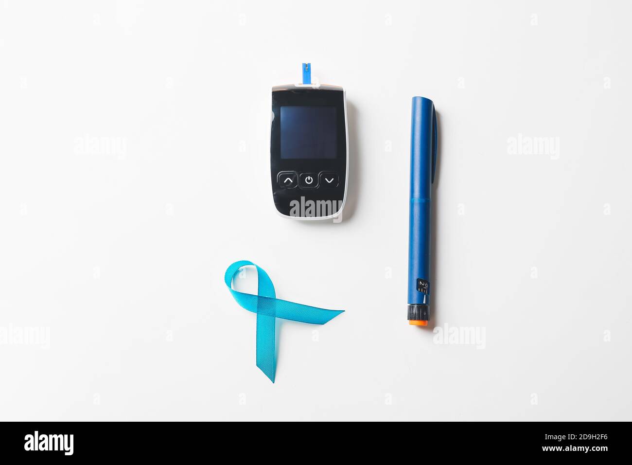 Awareness ribbon, glucometer and syringe on white background. Diabetes ...