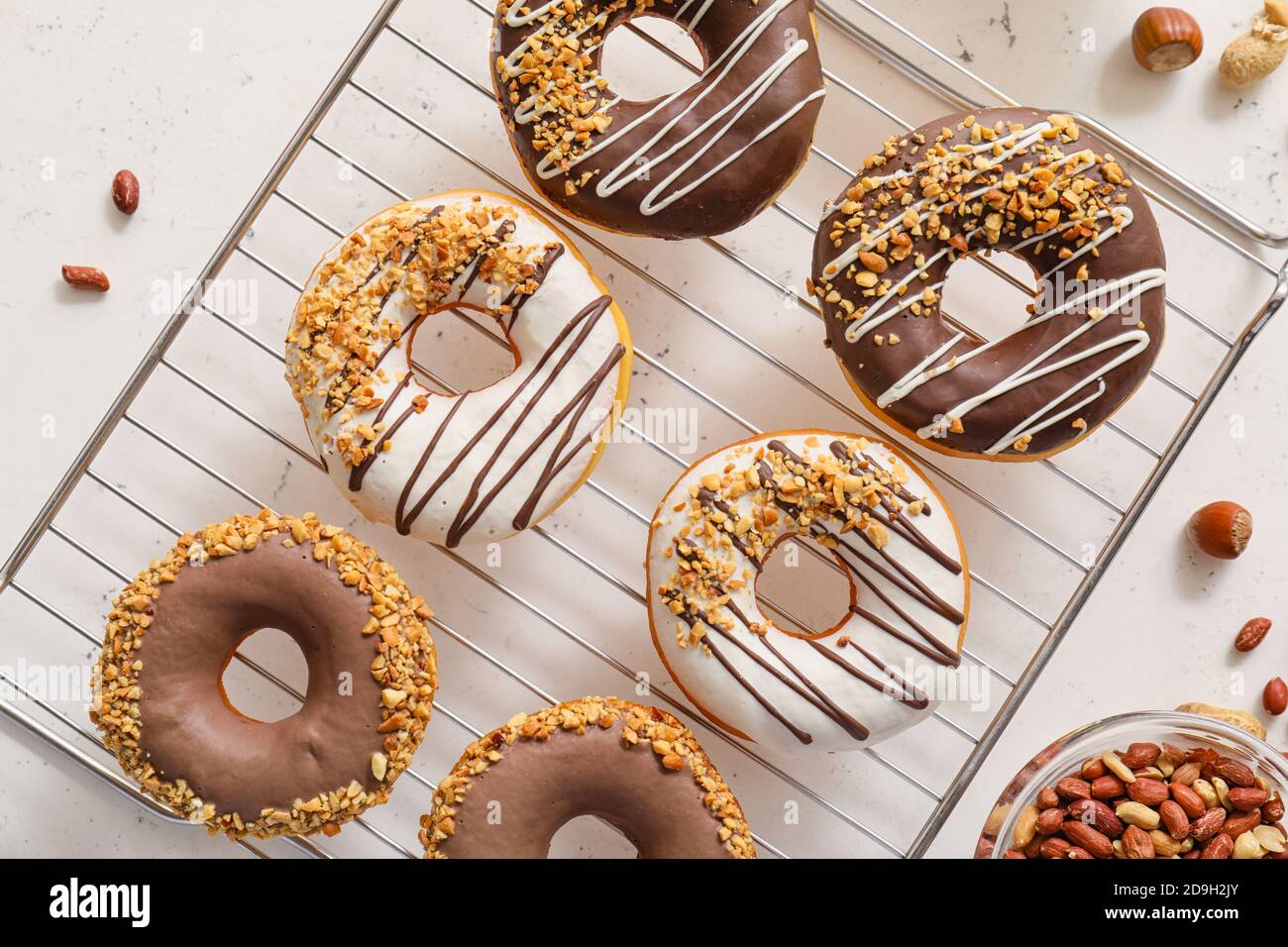 Cooling rack with tasty donuts on light background Stock Photo - Alamy
