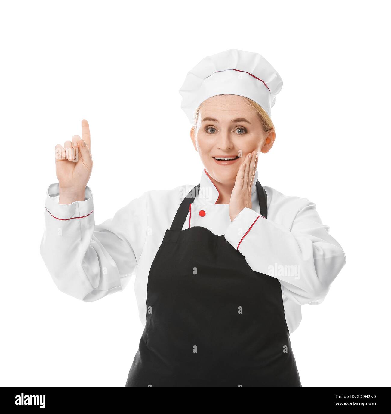 Surprised female chef pointing at something on white background Stock ...