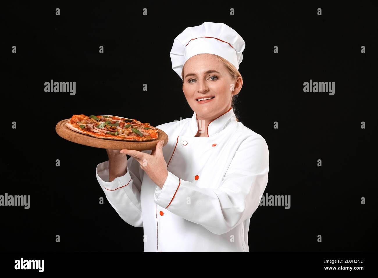 Mature female chef with tasty pizza on dark background Stock Photo - Alamy