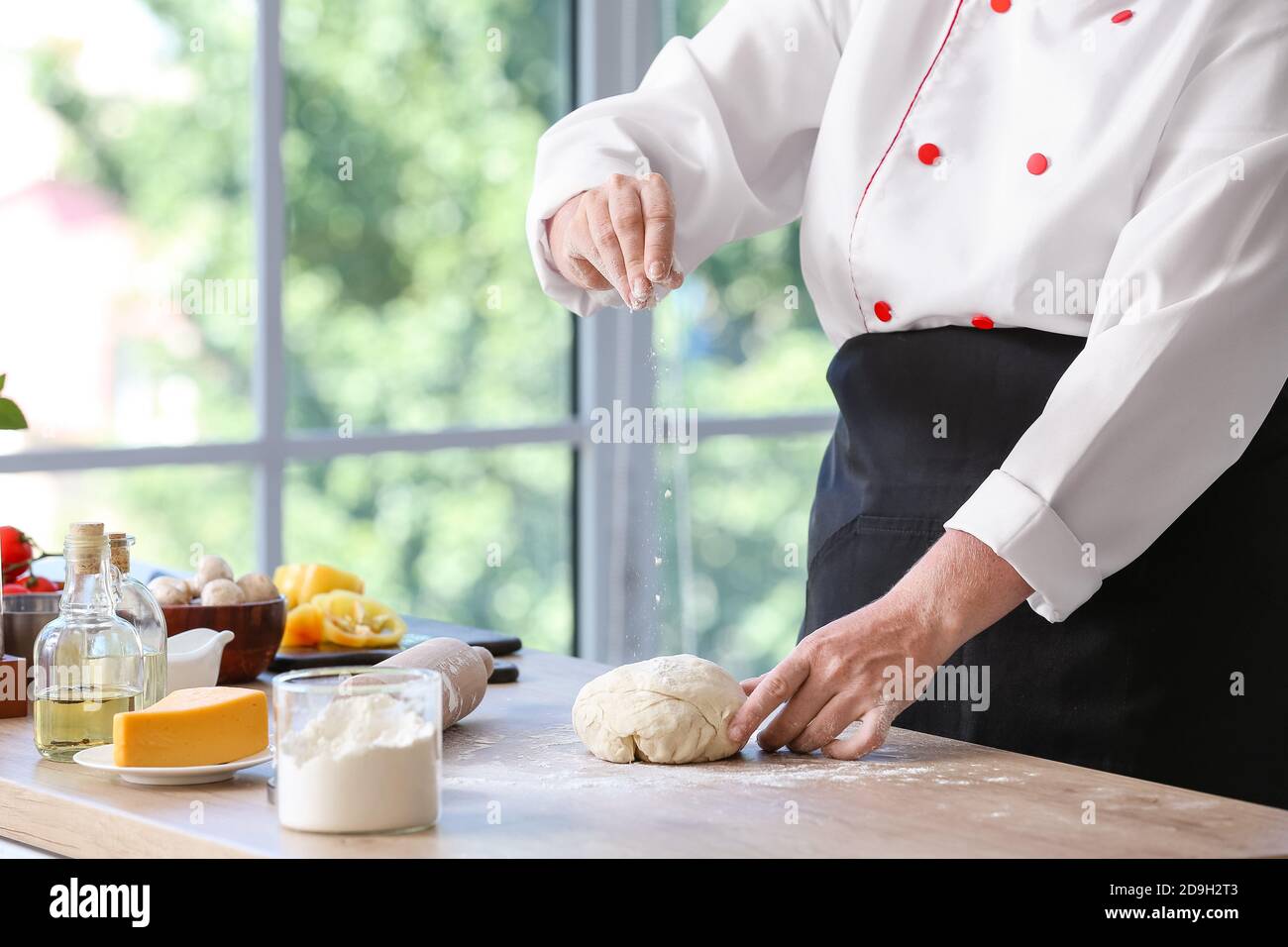 Female chef making dough in kitchen Stock Photo - Alamy
