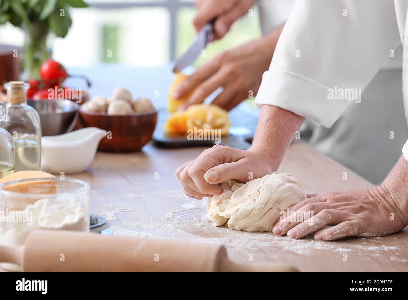 Female chef making dough in kitchen, closeup Stock Photo - Alamy