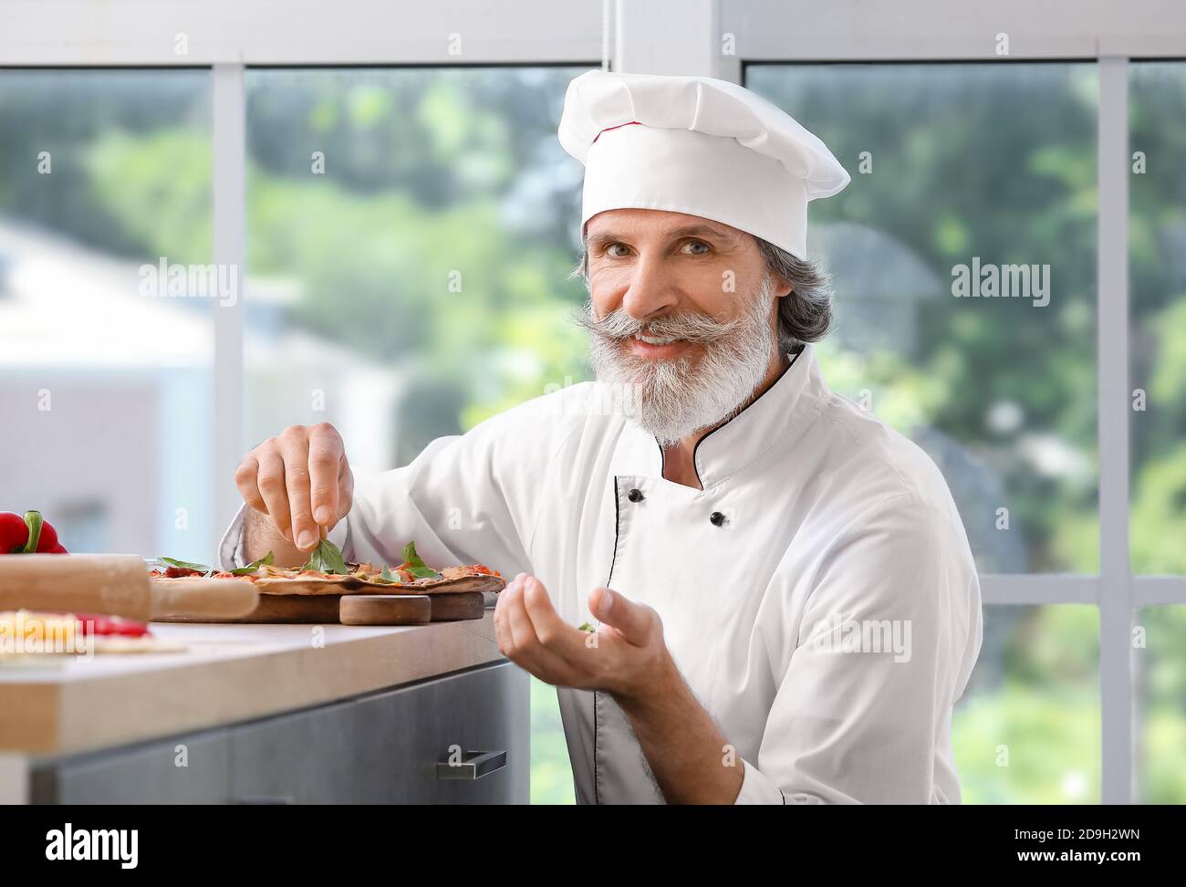 Mature male chef with tasty pizza in kitchen Stock Photo - Alamy