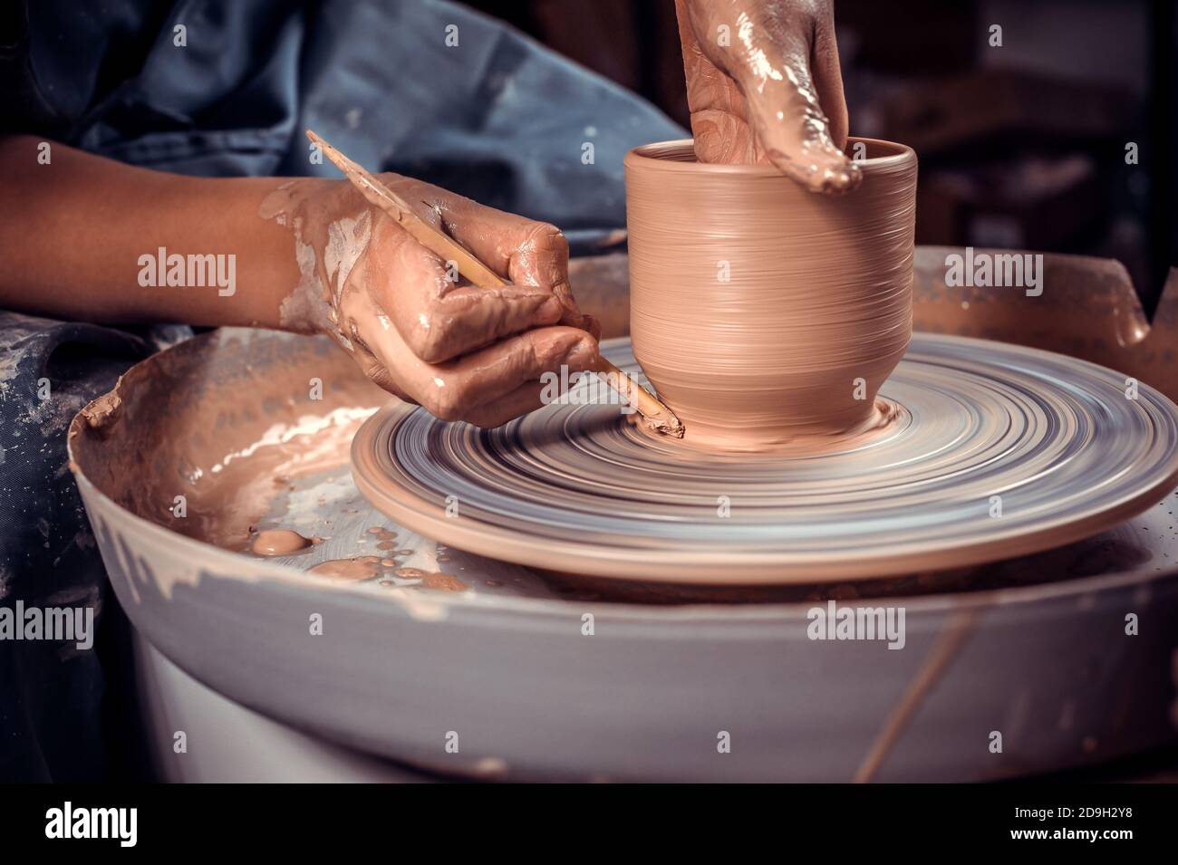 Craftsman master sculptor works with clay on a Potter's wheel and at ...