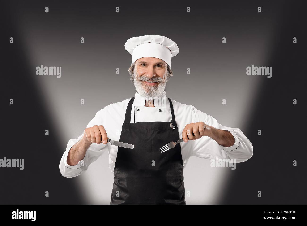 Mature male chef on dark background Stock Photo - Alamy