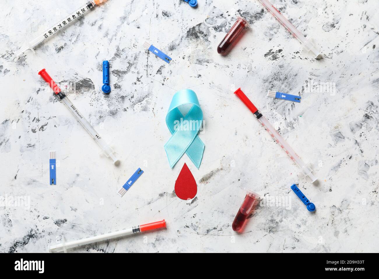 Awareness ribbon with blood samples, test strips and syringes on white ...