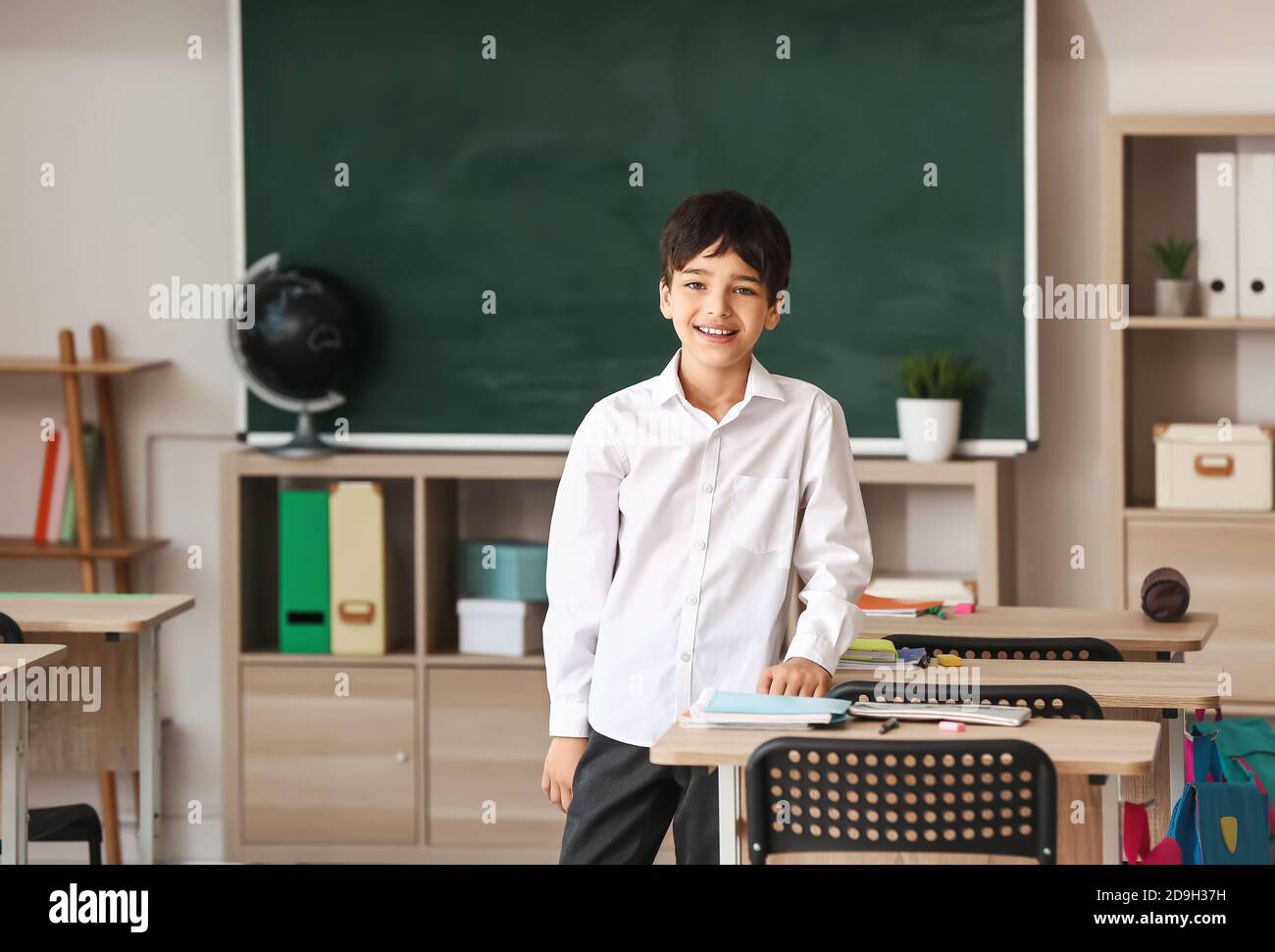 Cute little schoolboy in classroom Stock Photo - Alamy