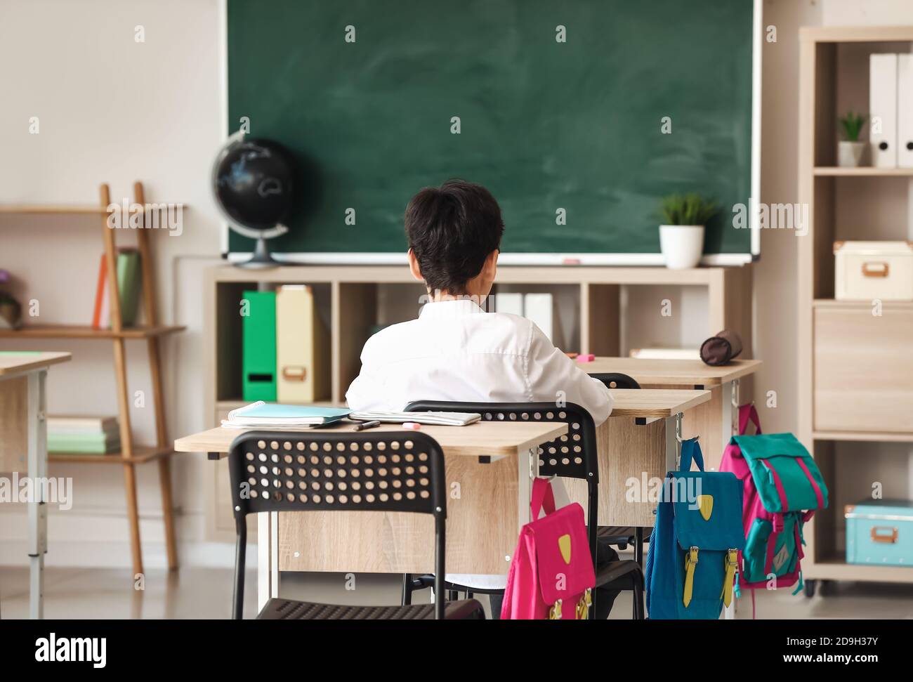 Cute little schoolboy in classroom Stock Photo - Alamy