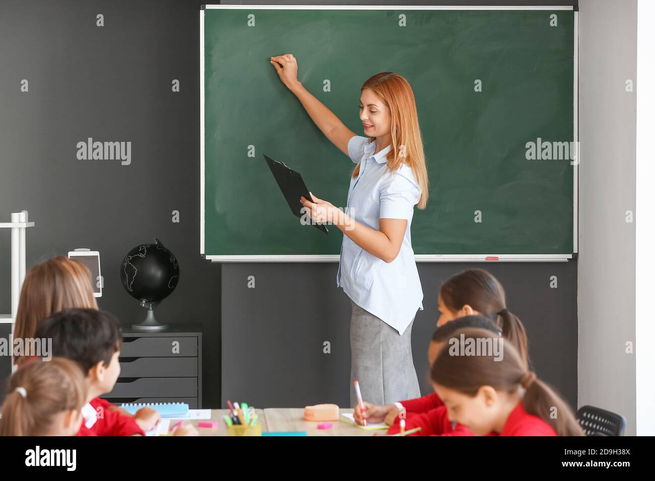 Teacher conducting lesson in classroom Stock Photo - Alamy