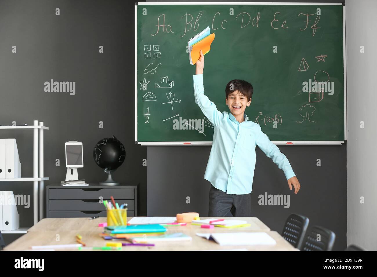 Happy little schoolboy near blackboard in classroom Stock Photo - Alamy