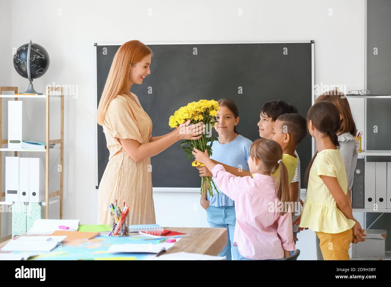 Schoolchildren greeting their teacher in classroom Stock Photo - Alamy