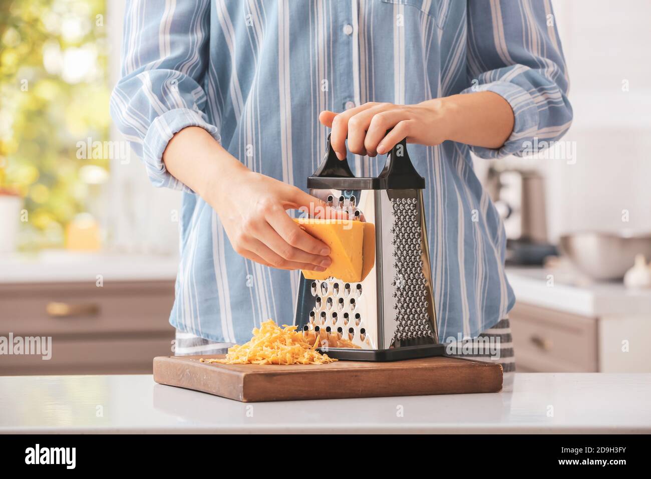 Woman grating cheese in kitchen Stock Photo - Alamy