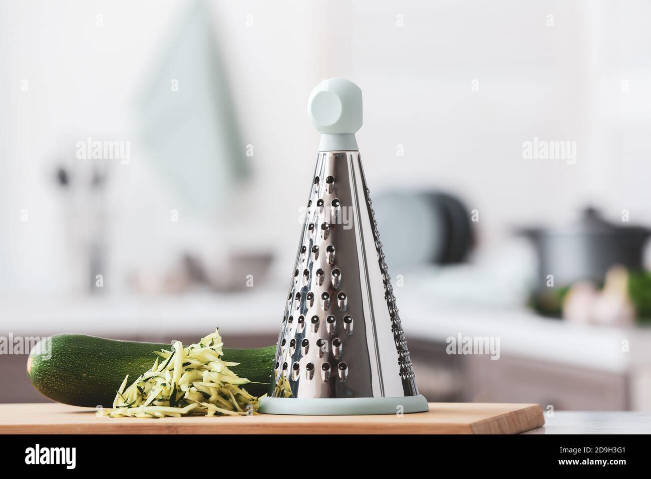 Metal grater and zucchini on kitchen table Stock Photo - Alamy
