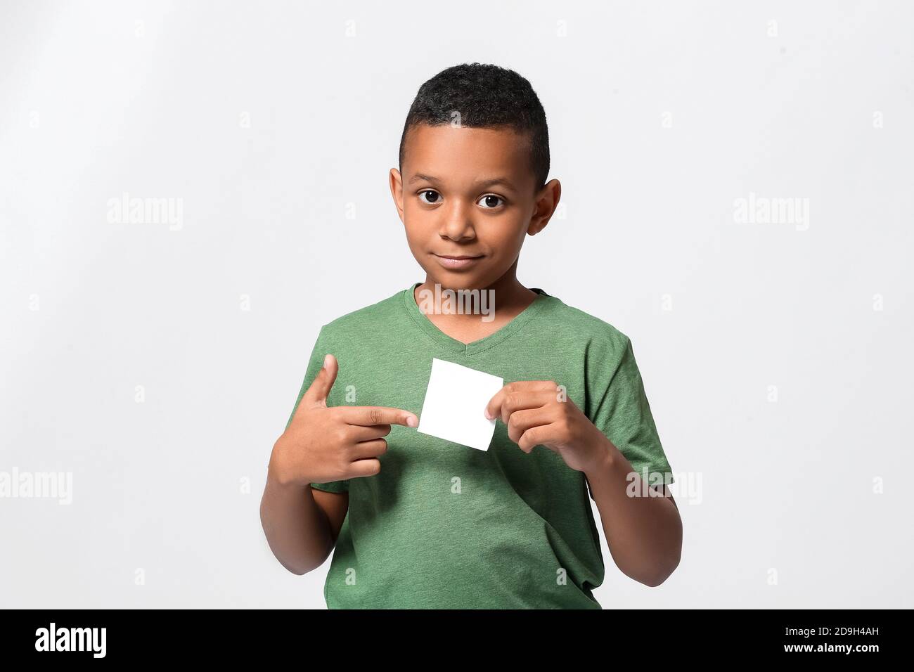 Little African-American boy with blank note paper against light ...