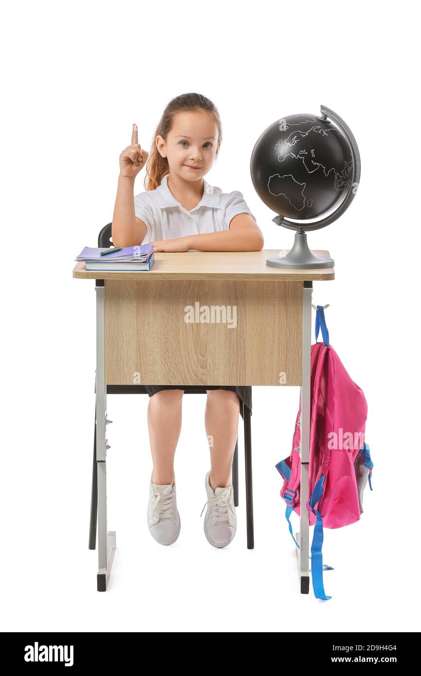Little pupil with raised index finger sitting at school desk against ...