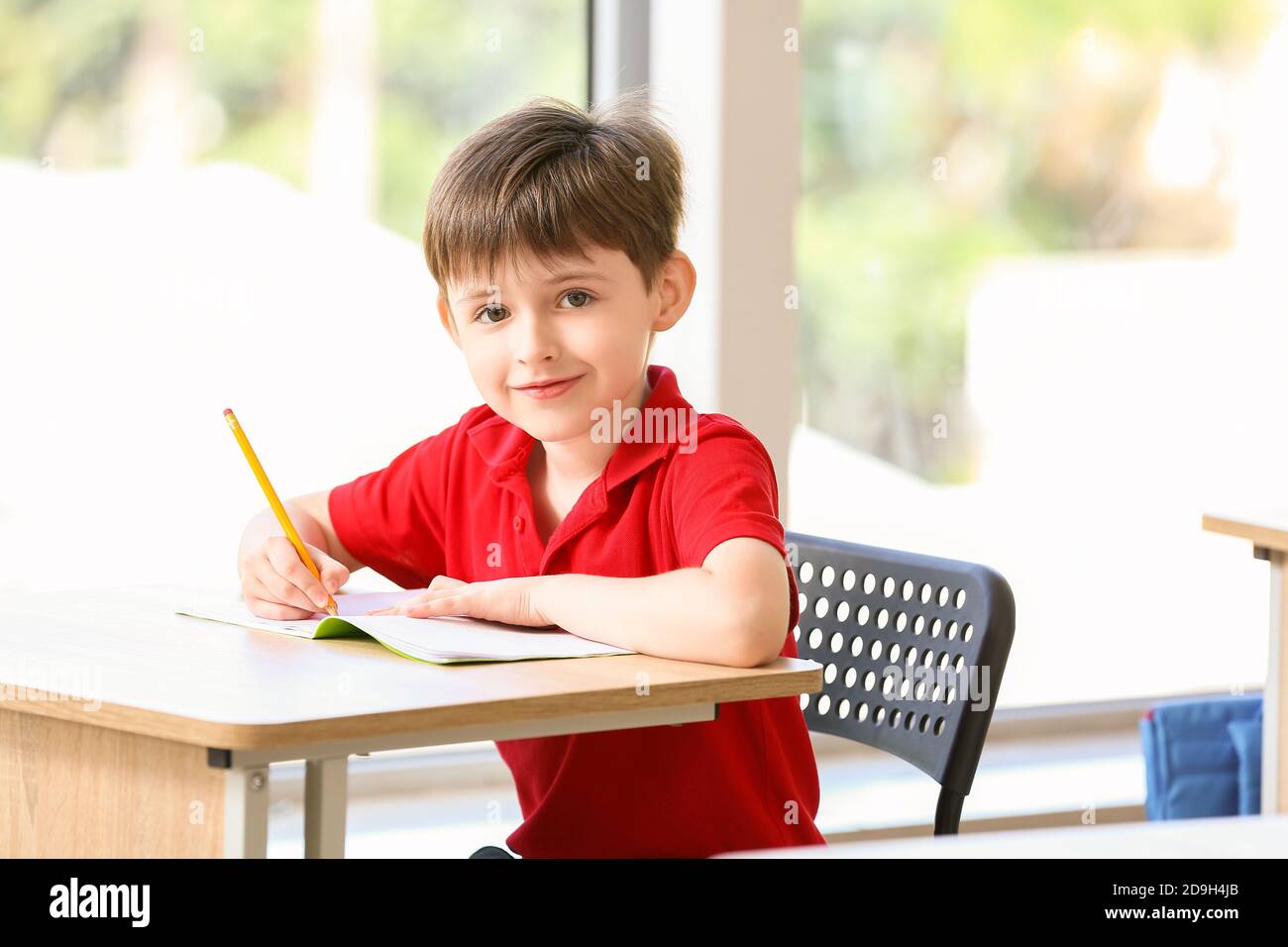 Cute schoolboy during lesson in classroom Stock Photo - Alamy