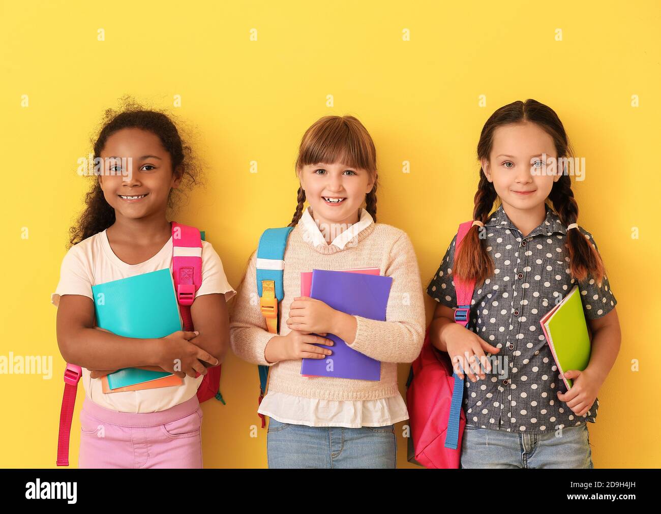 Cute pupils on color background Stock Photo - Alamy