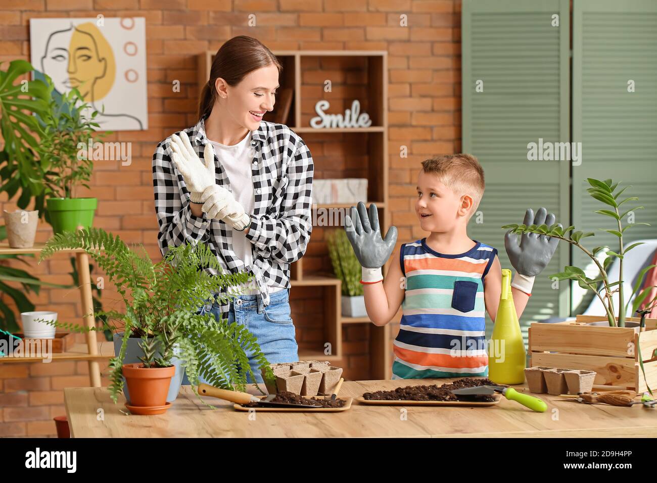 Young mother with son setting out plants at home Stock Photo - Alamy