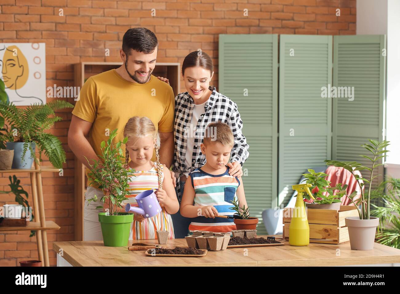 Young family setting out plants at home Stock Photo - Alamy