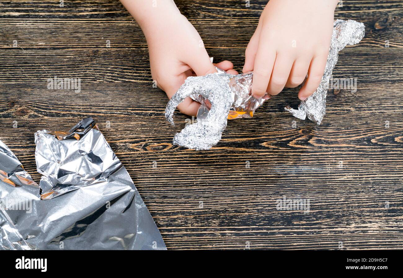 the boy creates different things from foil Stock Photo - Alamy