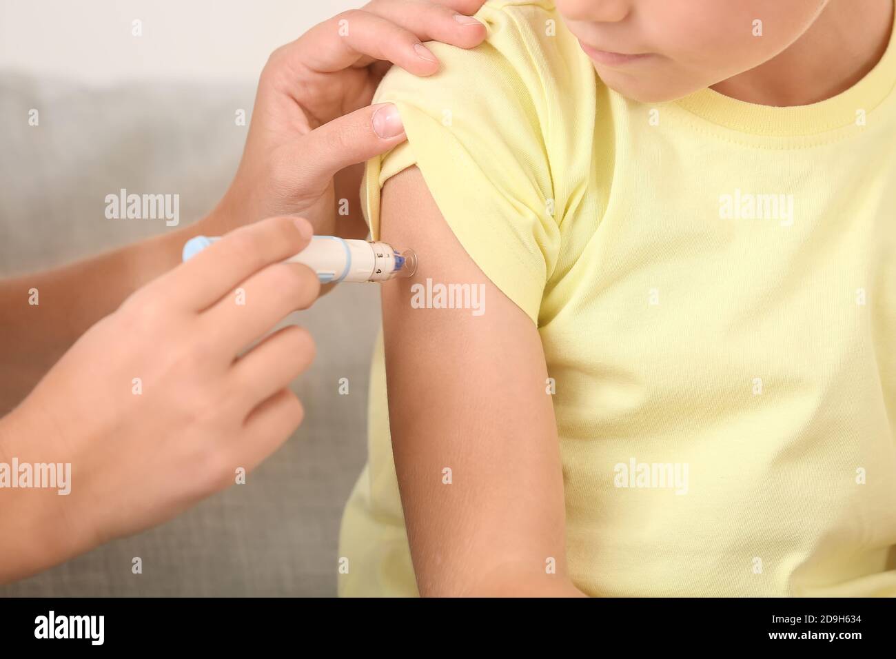 Mother giving her diabetic son insulin injection at home Stock Photo ...