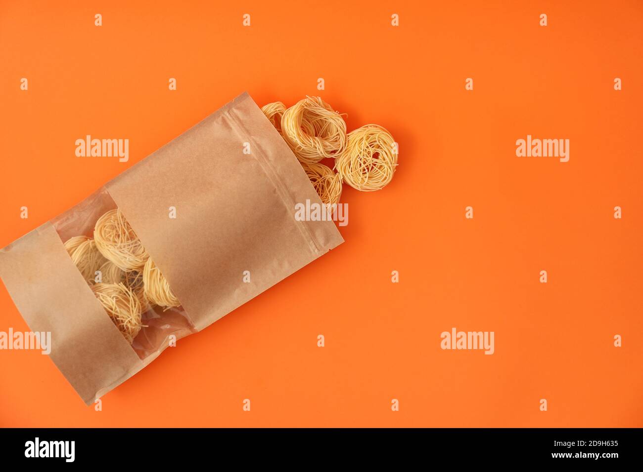 Paper bag with pasta on color background Stock Photo - Alamy