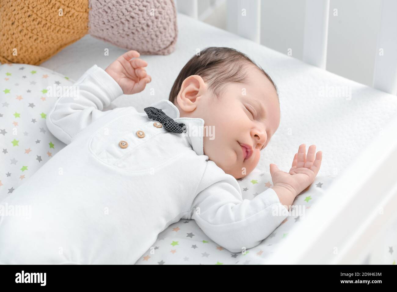 Cute little baby lying in crib Stock Photo - Alamy