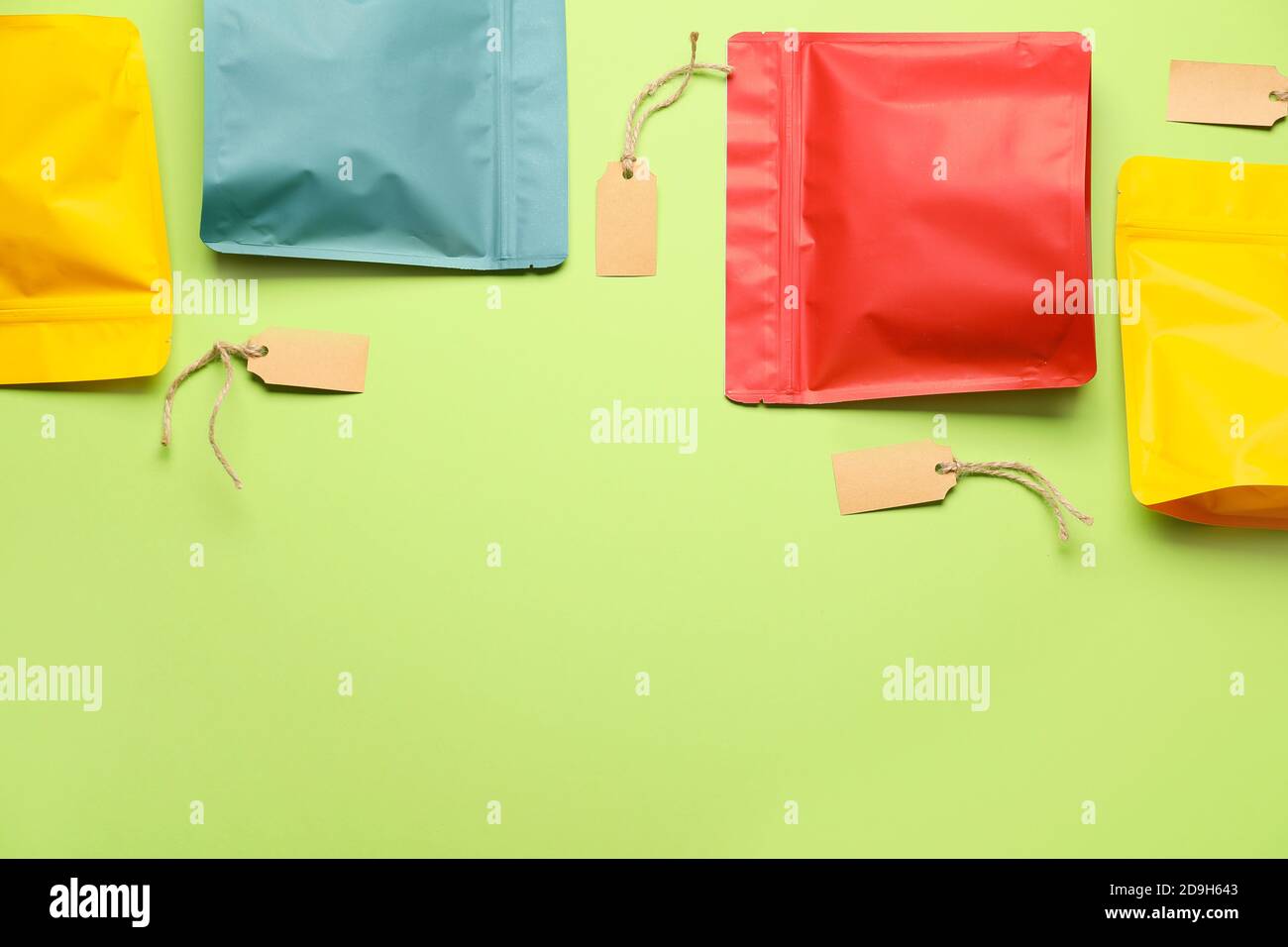 Blank bags with shopping tags on color background Stock Photo - Alamy