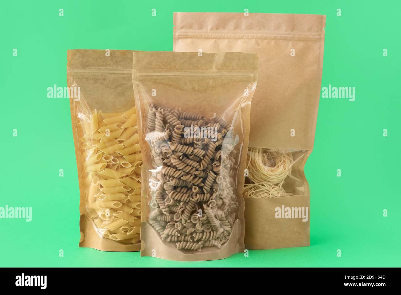 Bags with different pasta on color background Stock Photo - Alamy