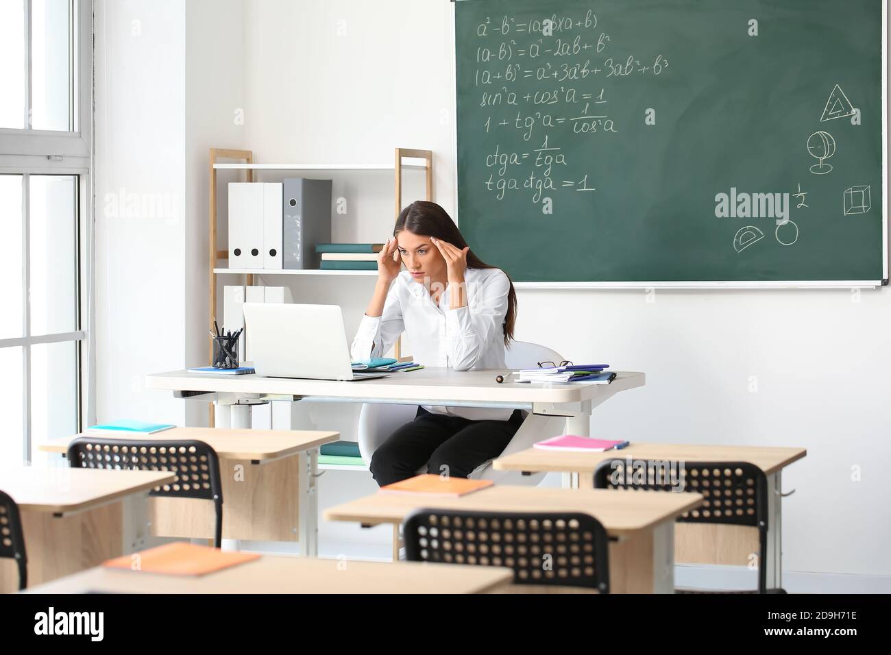 Stressed young female teacher in classroom Stock Photo - Alamy