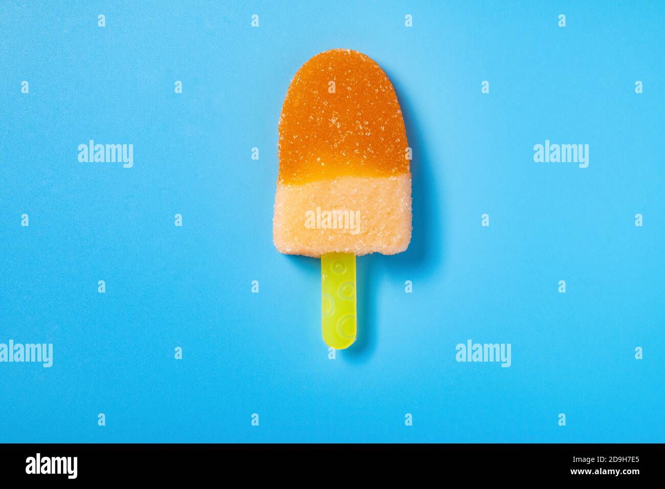 popsicle shape orange flavor chewy gum on a blue background Stock Photo ...