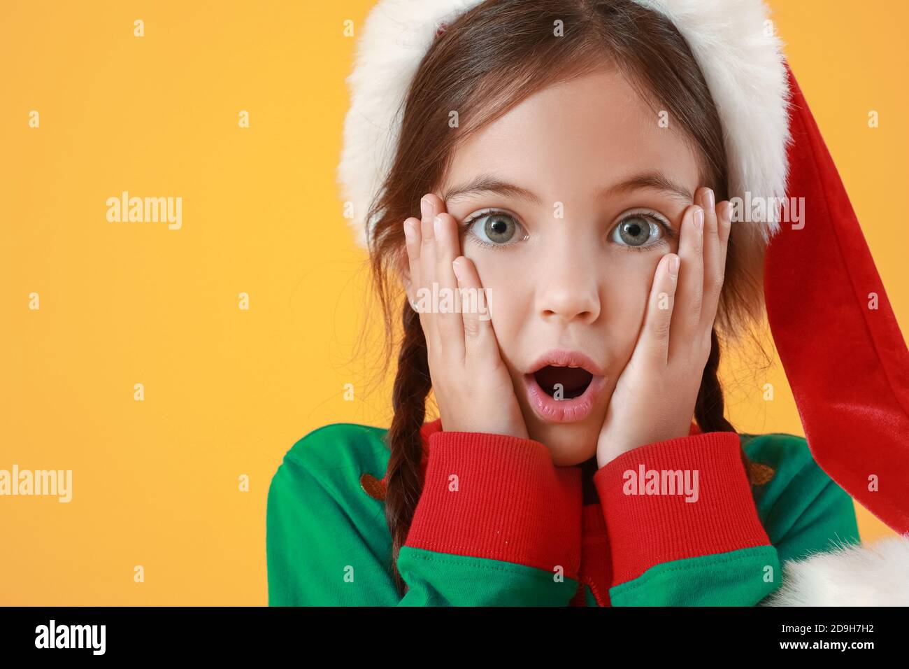 Surprised little girl dressed as elf on color background Stock Photo ...